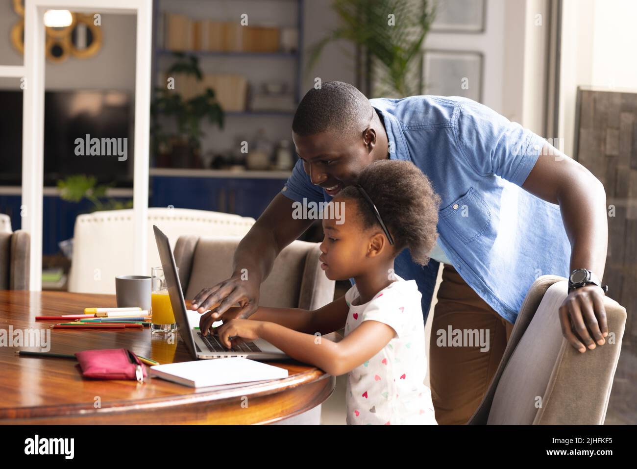 Happy african american father and daughter doing homework and working together Stock Photo - Alamy