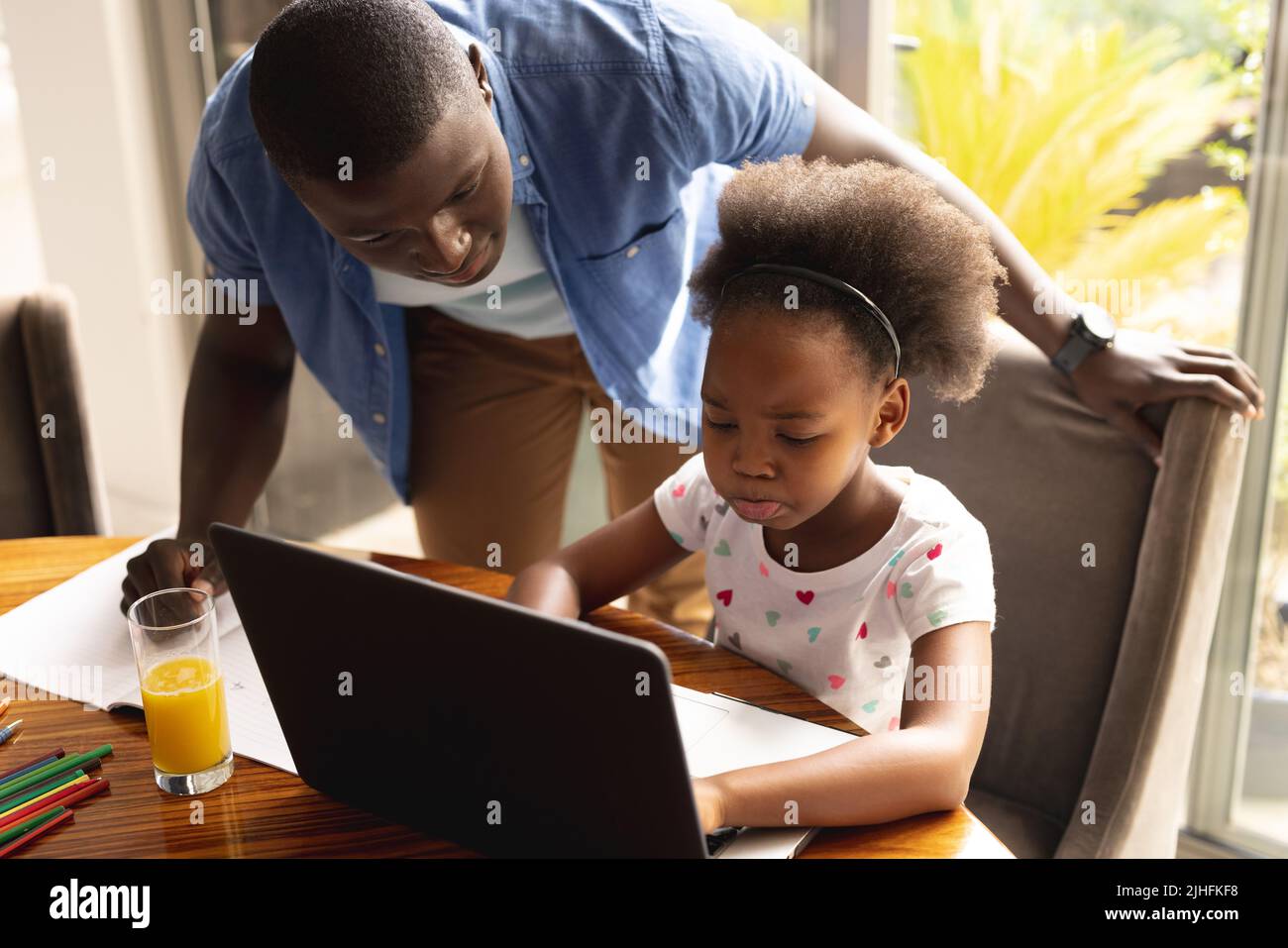 Happy african american father and daughter doing homework together Stock Photo - Alamy
