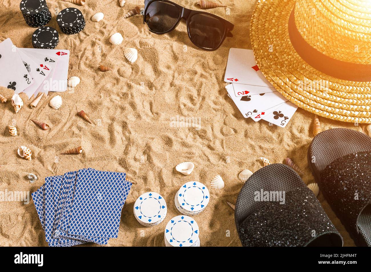 Beachpoker. Chips and cards on the sand. Around the seashells ...