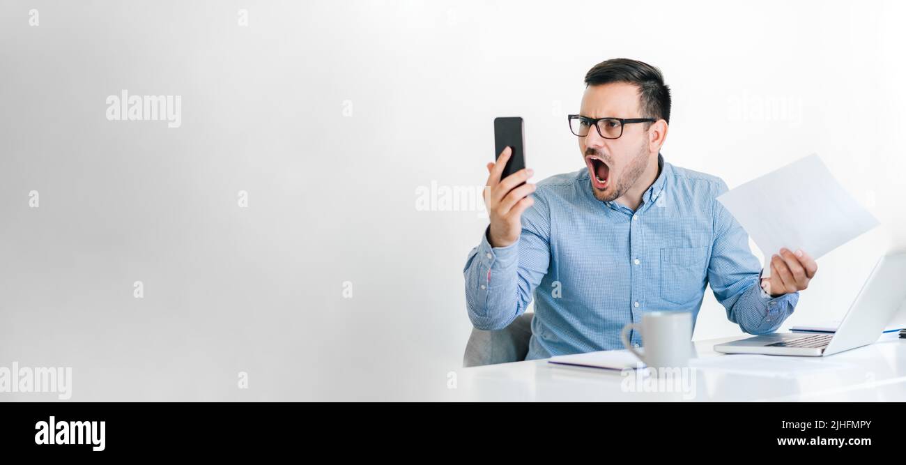 Angry nervous man office worker in blue shirt screaming looking at ...