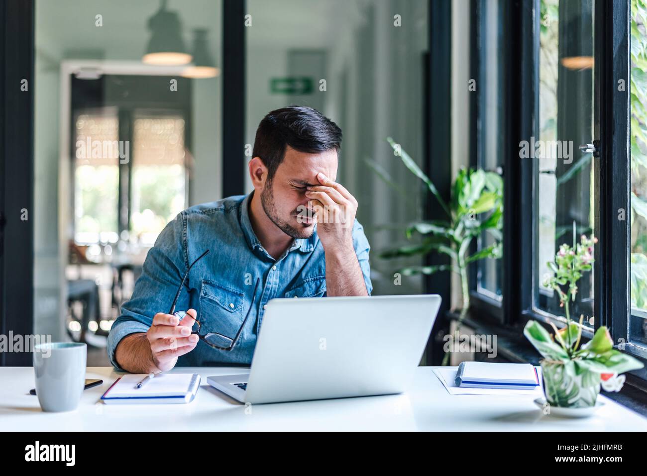 Tired young man feel pain eyestrain holding glasses rubbing dry ...