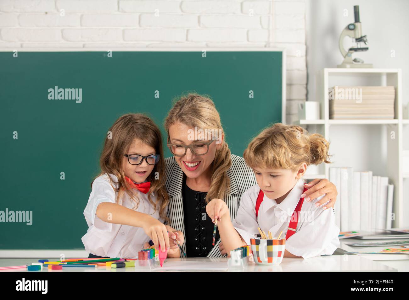 Schoolkids with teacher. Happy children from elementary school study at ...