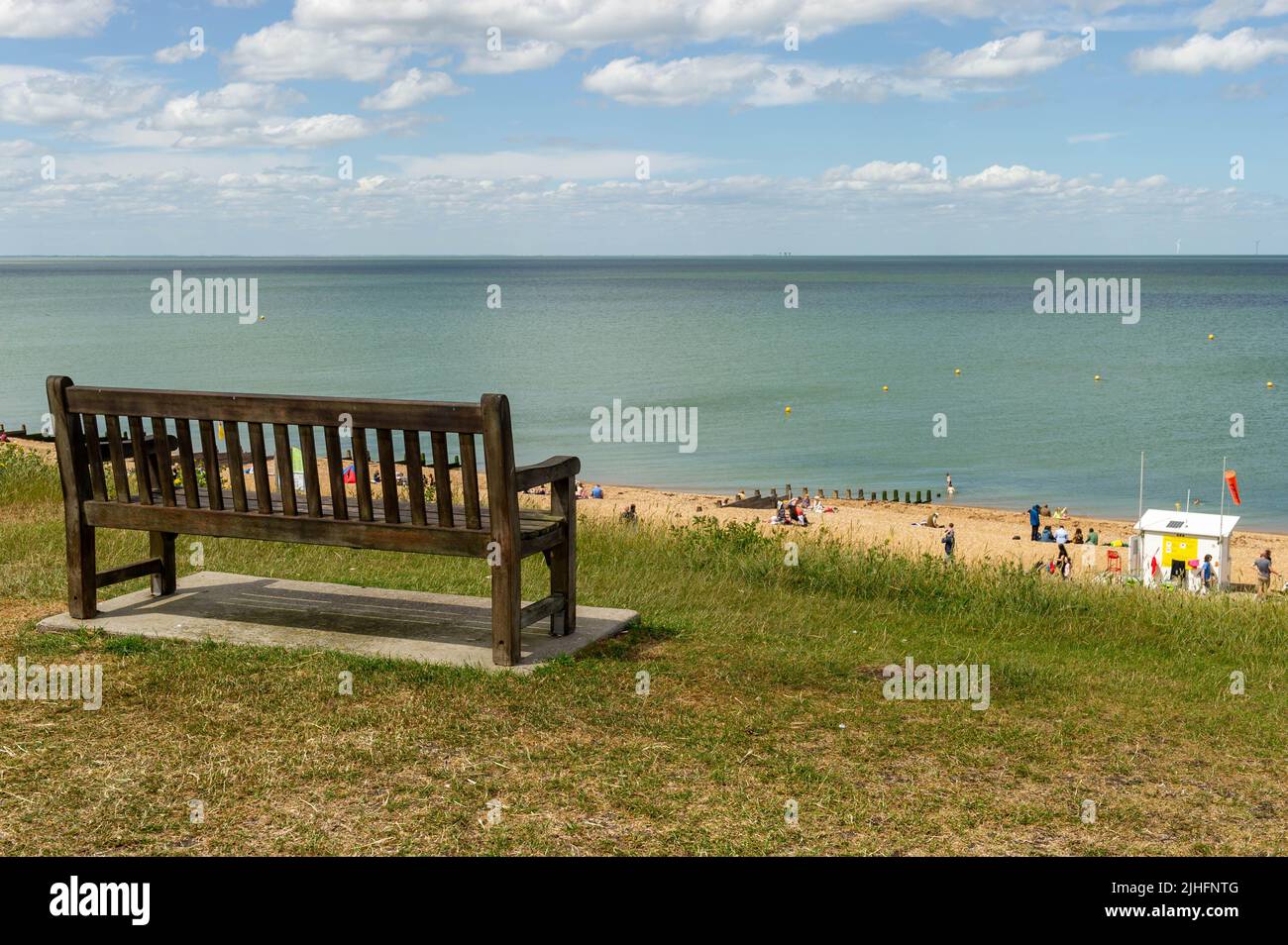 Wooden Bench, overlooking Tankerton beach on a sunny day, Kent, England ...