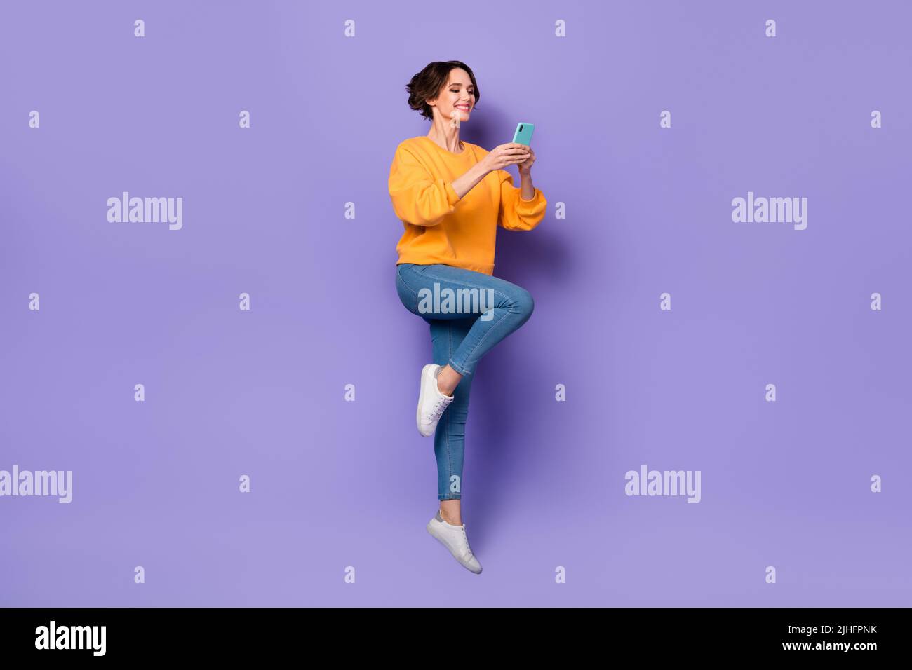 Full body portrait of active carefree girl hold telephone chatting ...