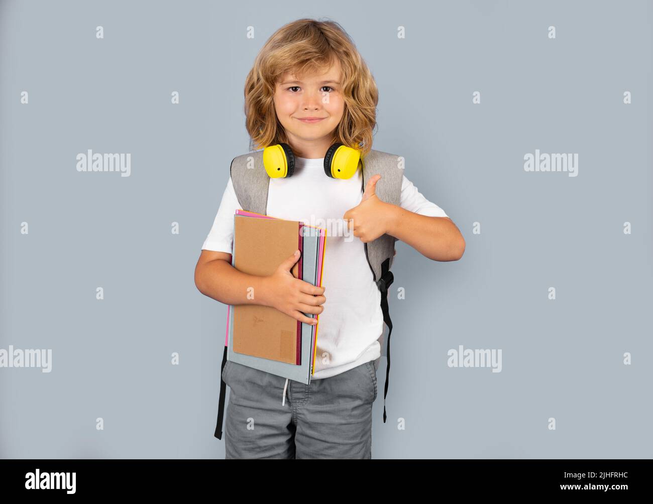 Portrait of pupil student hold book on grey isolated studio background ...