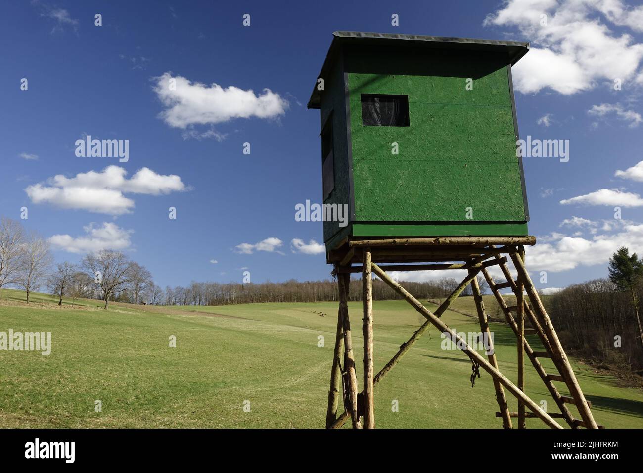 The view of a green watchtower in the green field by the woods Stock ...