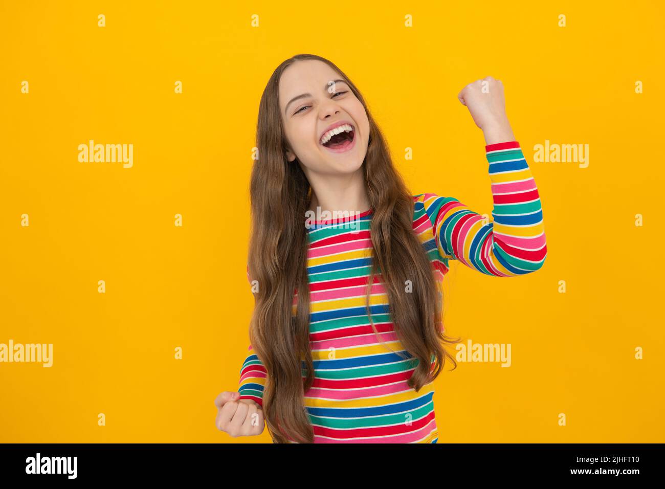 Studio portrait of teenager child doing winner gesture. Kid rejoicing ...