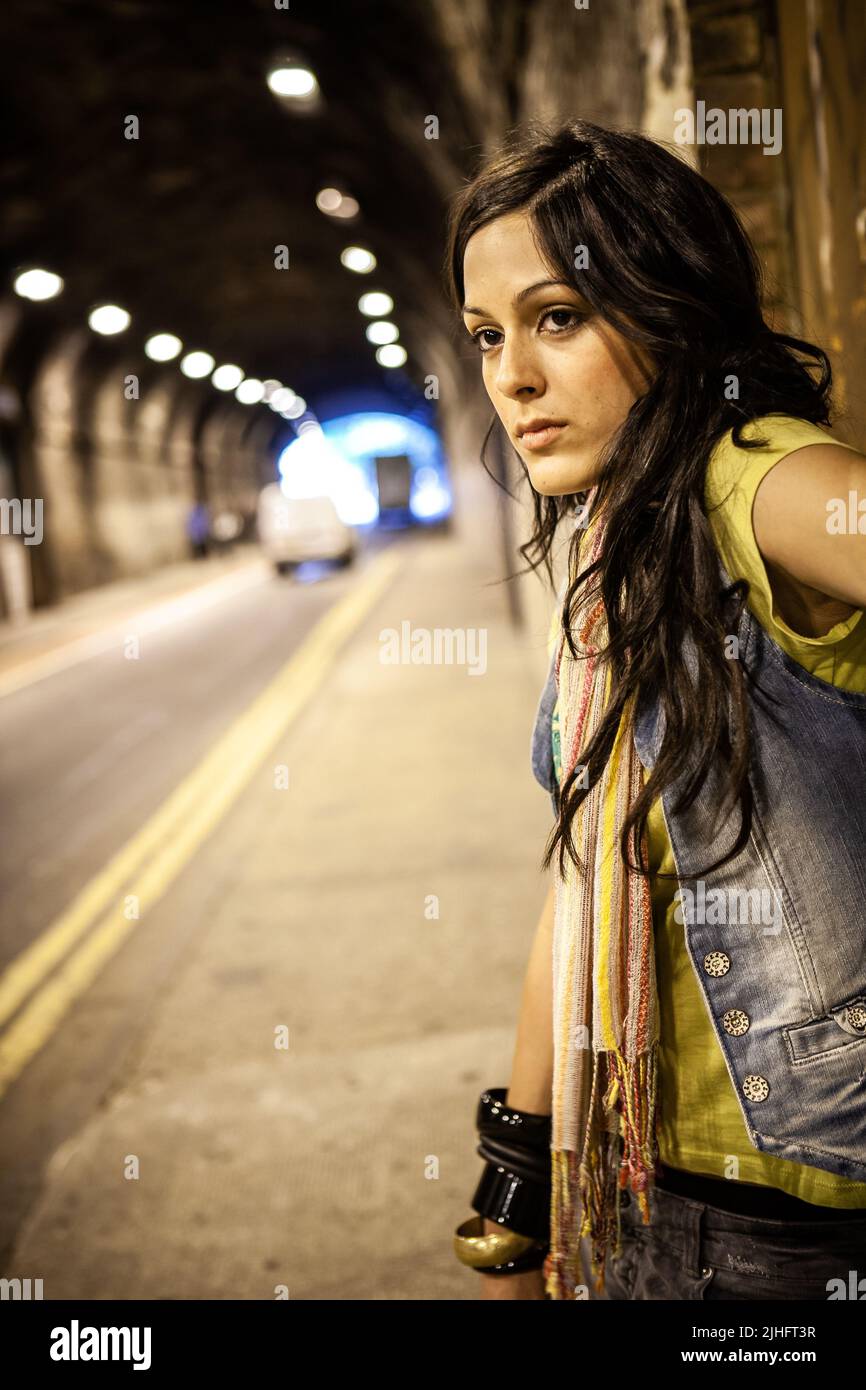 Urban Fashion. A beautiful young mixed race model on location waiting ...