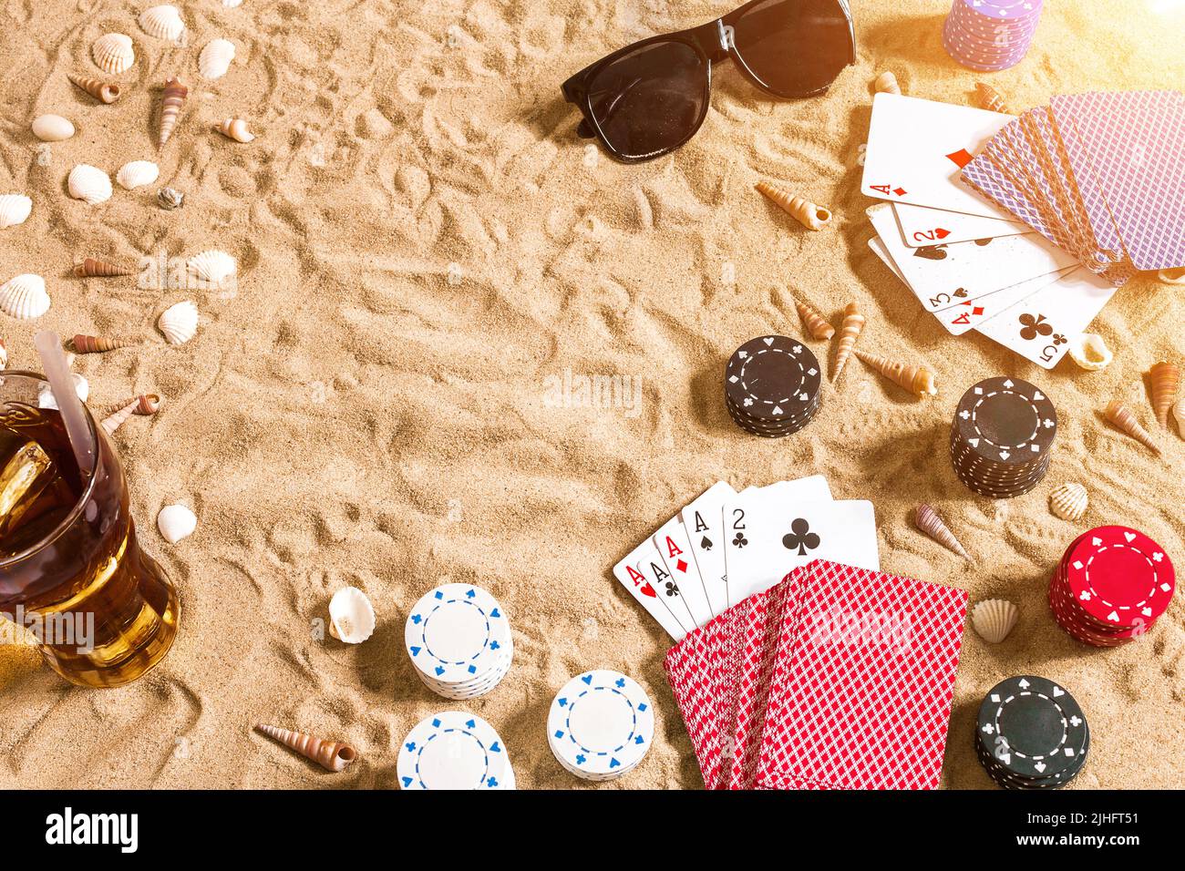 Beachpoker. Chips and cards on the sand. Around the seashells ...