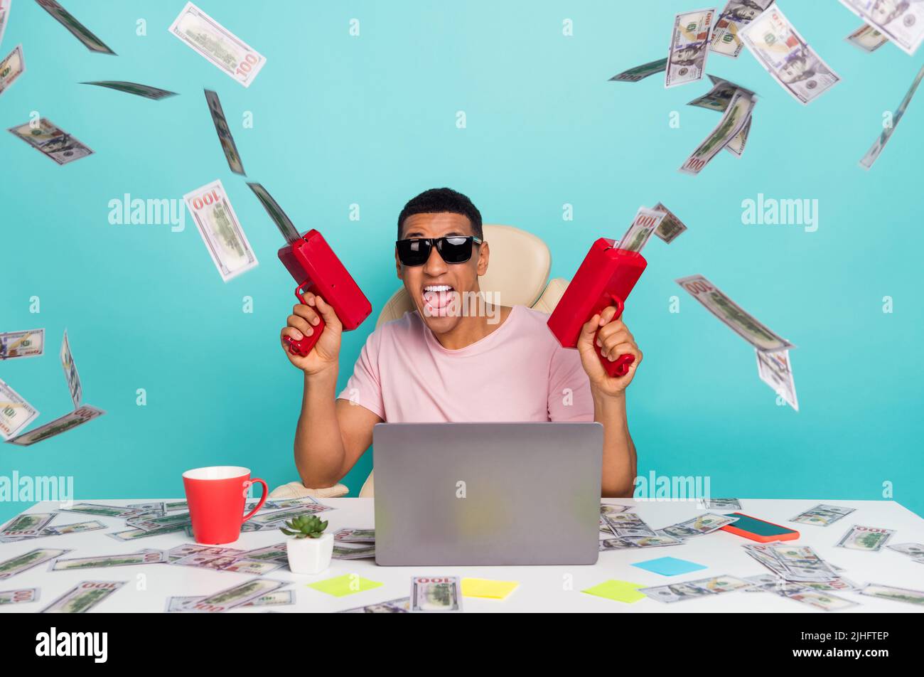 Photo of lucky cool man dressed pink t-shirt glasses shooting money gun ...