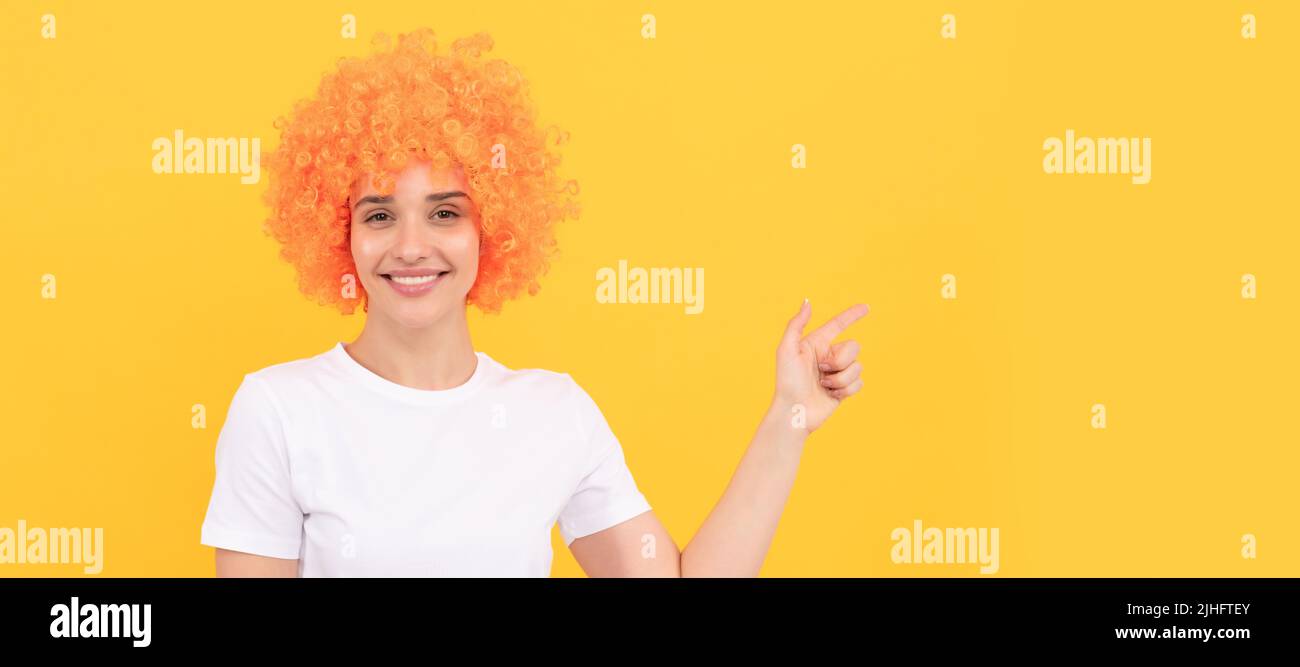happy freaky woman in curly clown wig pointing finger, gesture and ...