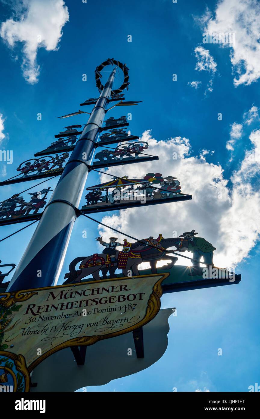 A vertical low-angle shot of the famous Bavarian maypole in Munich ...