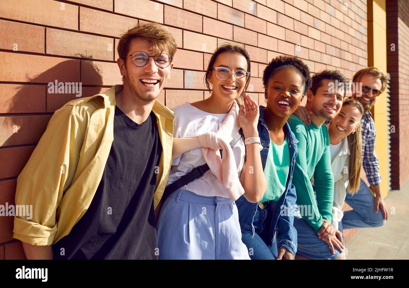 Multiracial group of happy young people meeting on city streets and ...