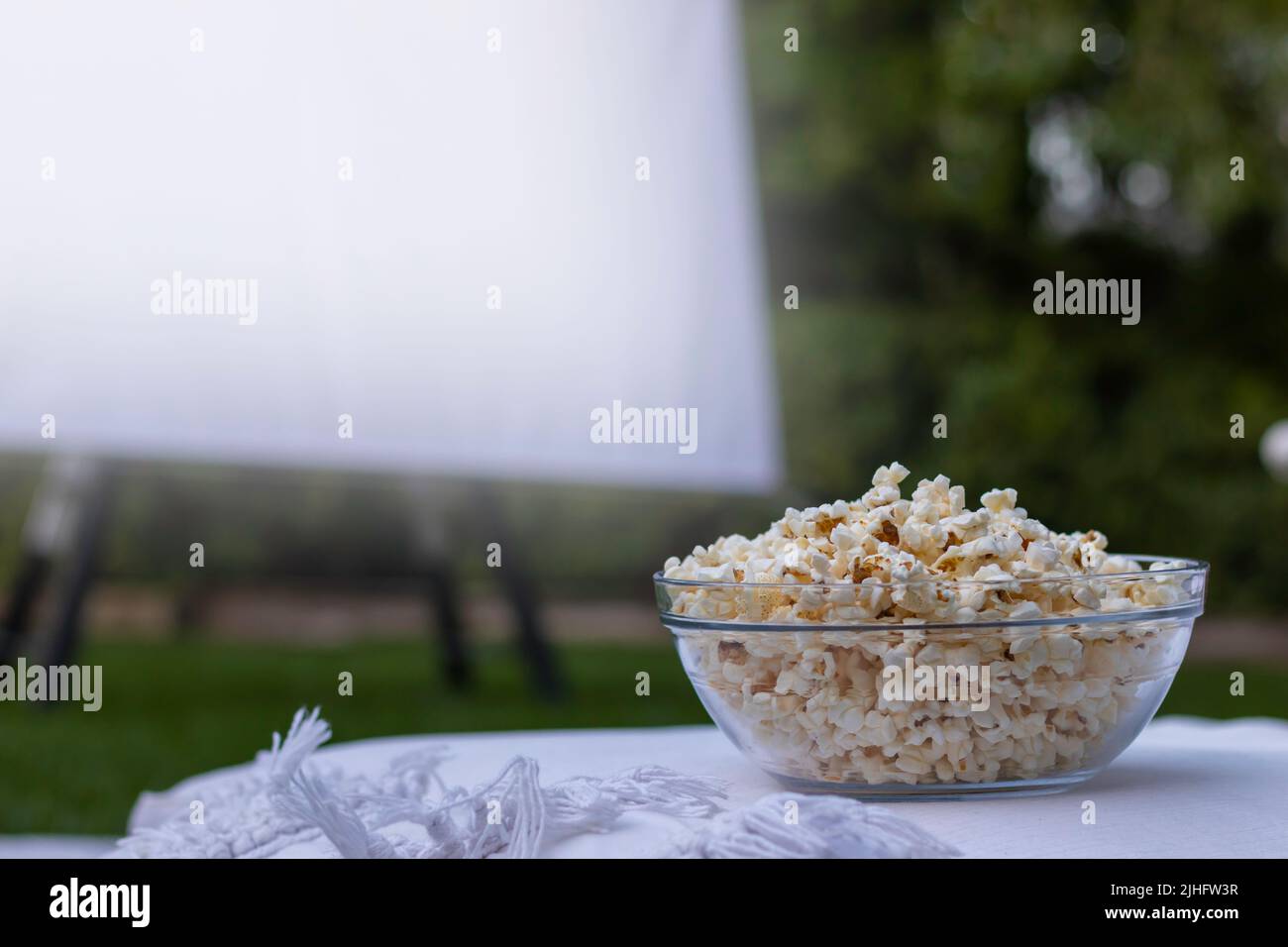 Close up view of clear popcorn bowl with a projector screen in the ...