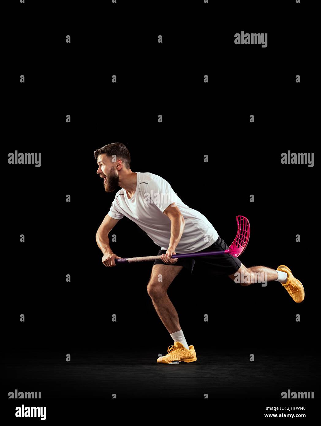 Studio shot of young man wearing sports uniform and sneakers playing ...