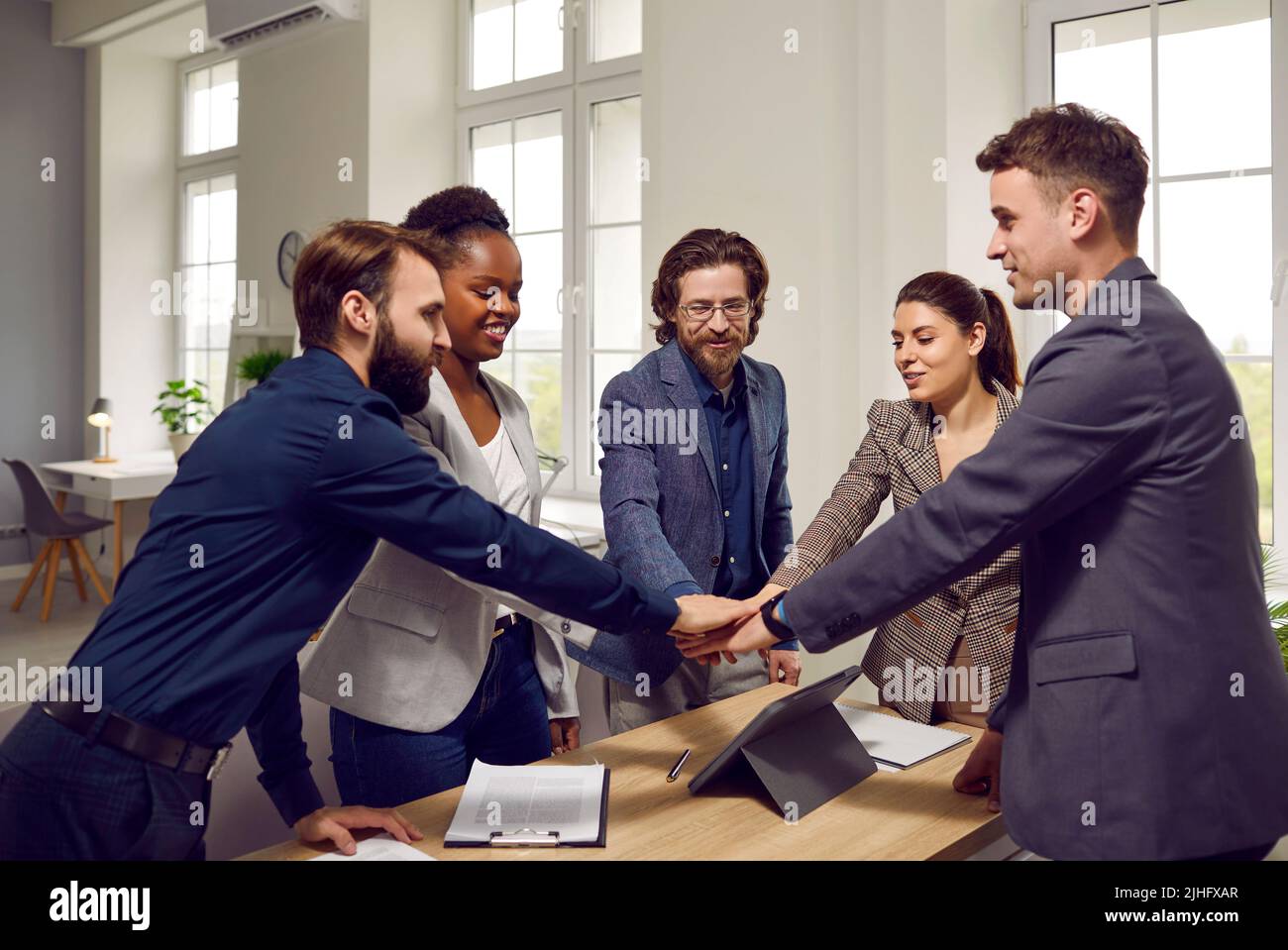 Cheerful business team in good mood together tunes in to workflow and ...