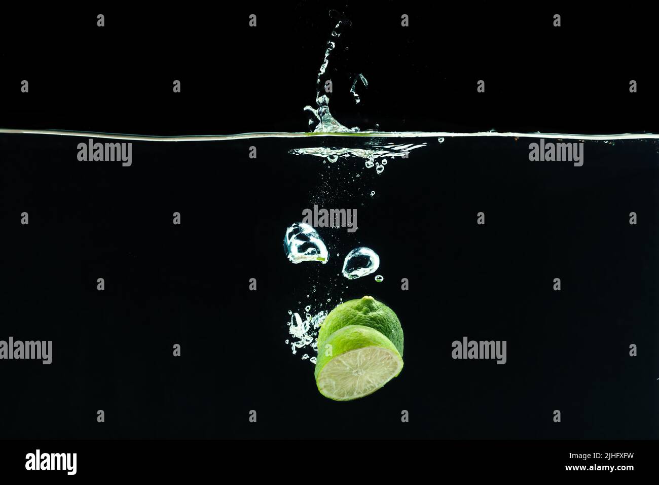 Fresh lime dropped into water with splash Stock Photo - Alamy