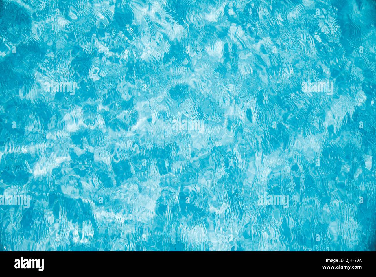 Water background, surface of the pool in ripples and sun glare. Nature ...