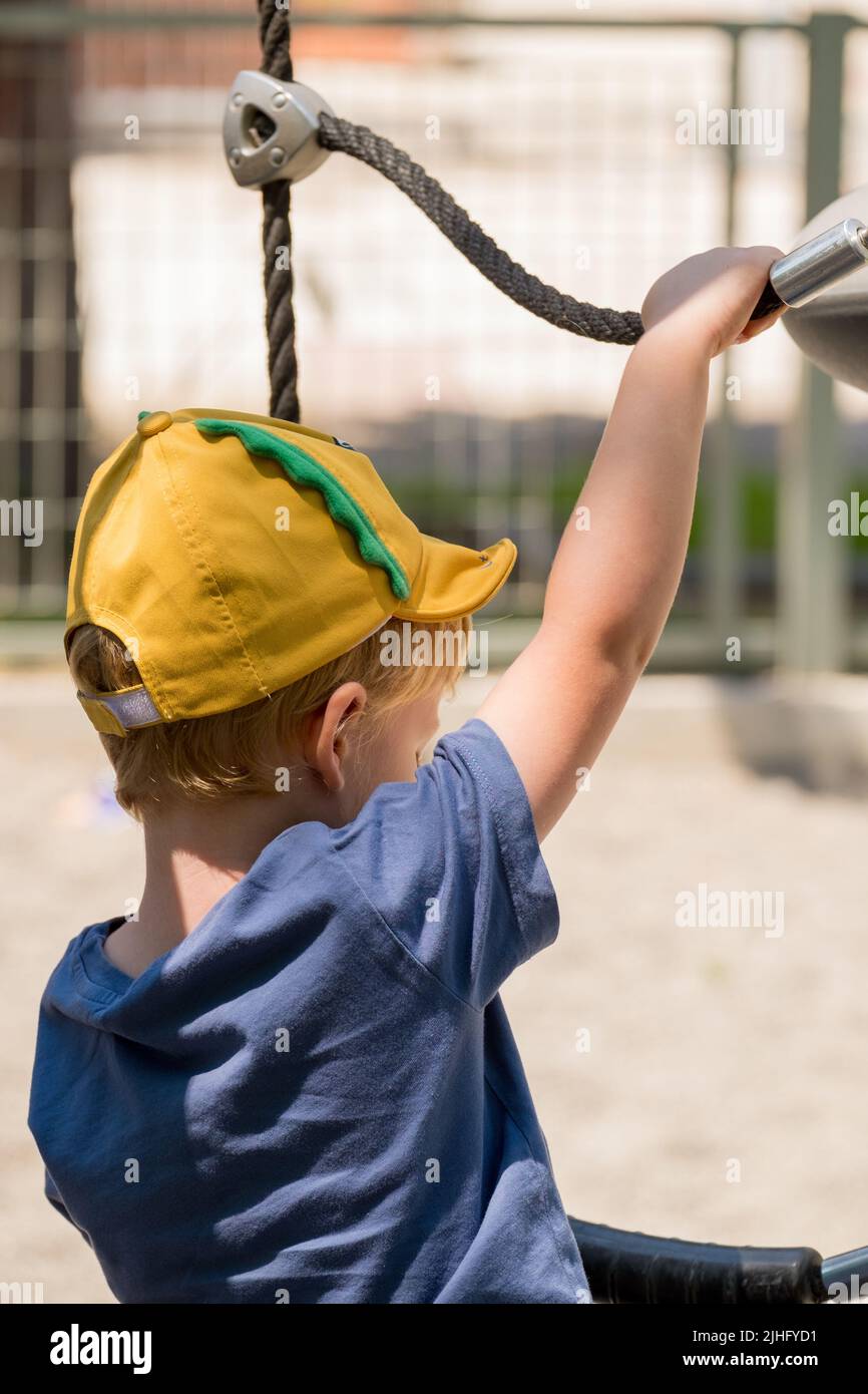 Little boy climbing ropes in the playground Stock Photo - Alamy
