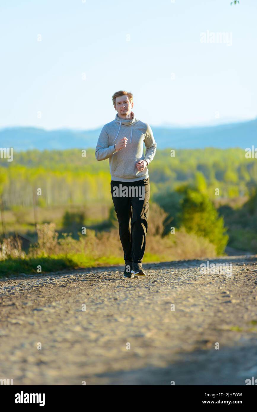 Running man jogging in rural nature at beautiful summer day. Sport ...