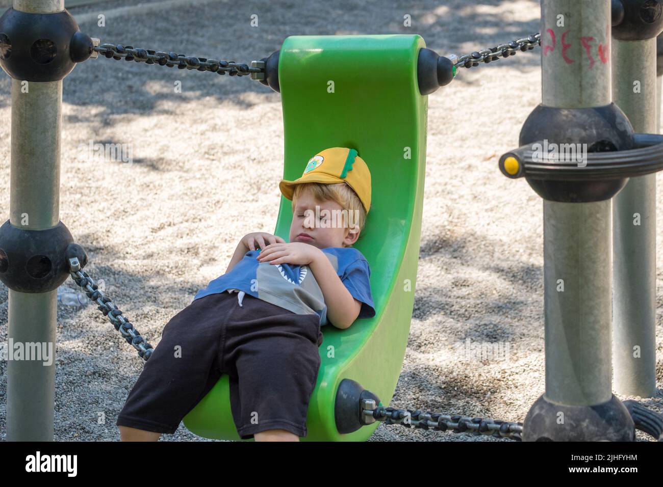 Little boy pretending he is sleeping in the playground Stock Photo - Alamy