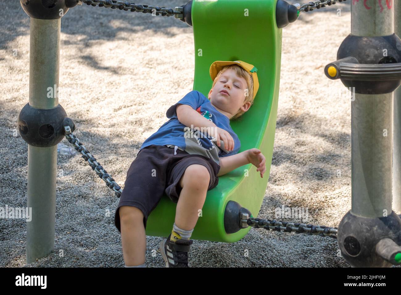 Little boy pretending he is sleeping in the playground Stock Photo - Alamy