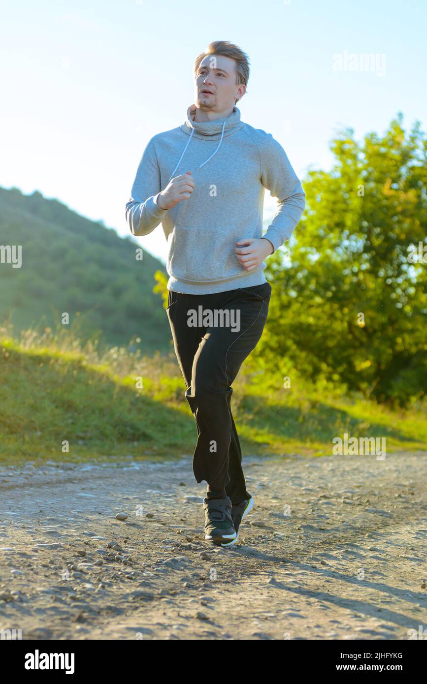 Running man jogging in rural nature at beautiful summer day. Sport ...