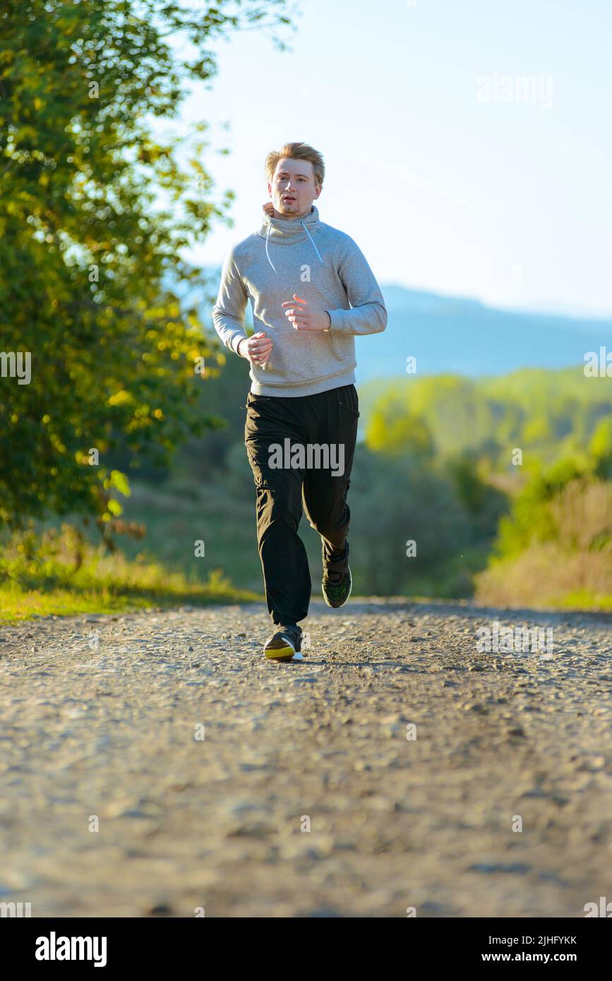 Running man jogging in rural nature at beautiful summer day. Sport ...