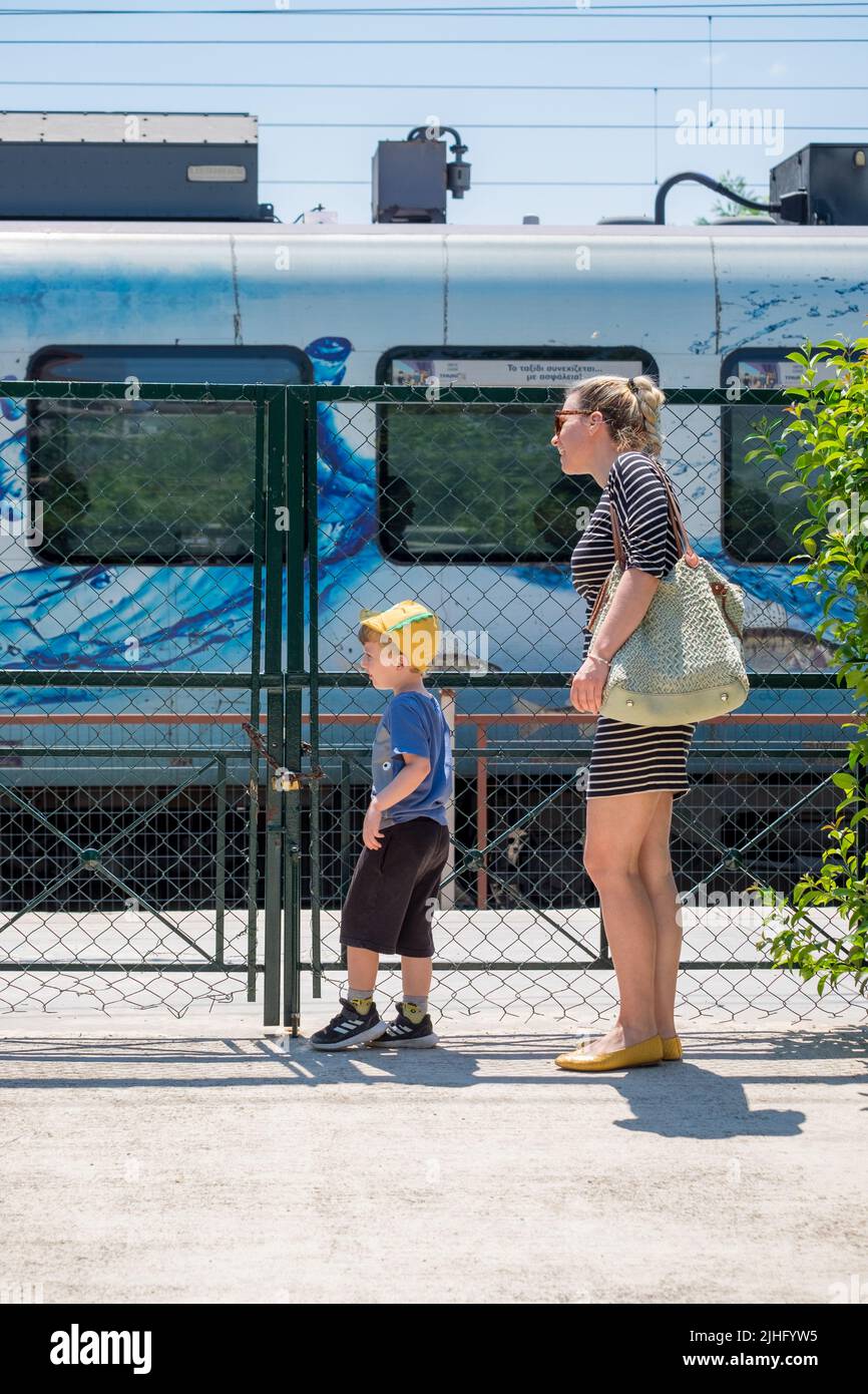 Adorable little boy staring with his mother the train in a train ...