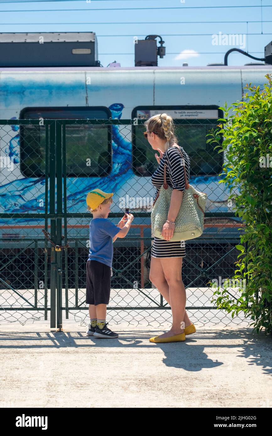 Adorable little boy staring with his mother the train in a train ...