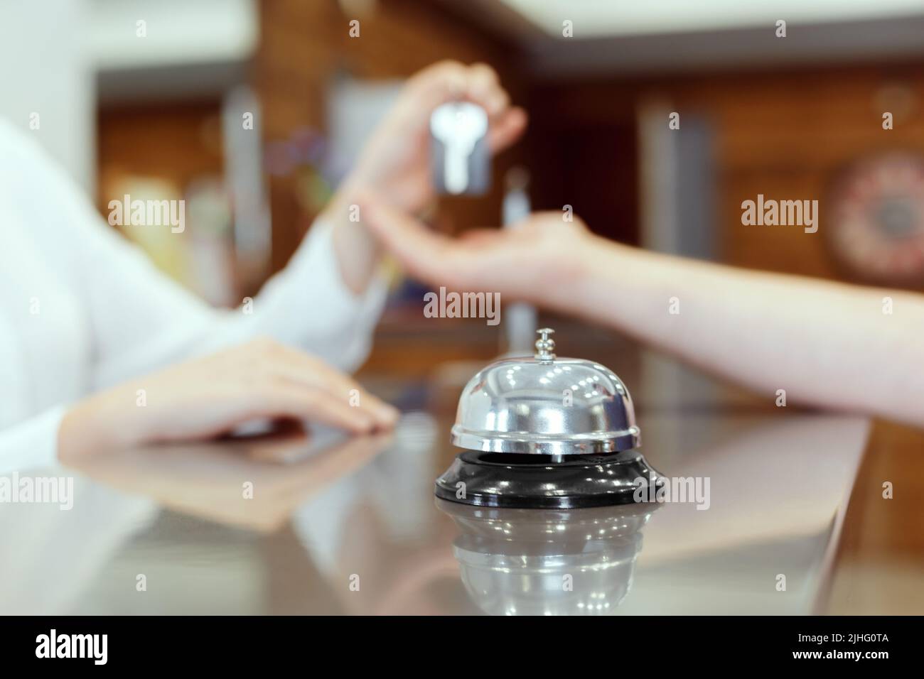 receptionist giving key Stock Photo - Alamy