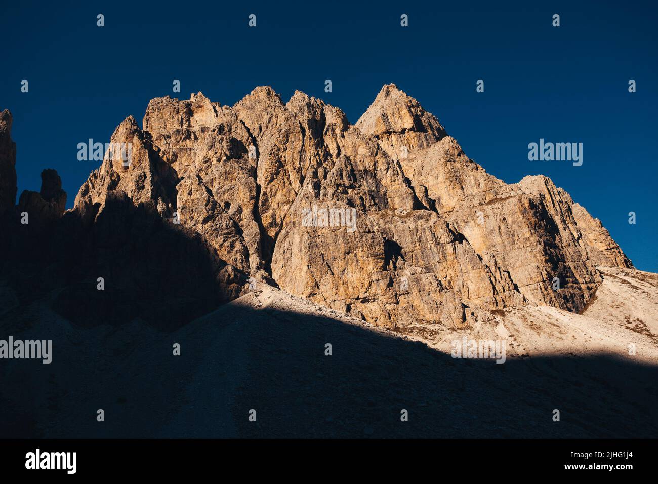 Rocky walls illuminated by the last rays of the sun in Comelico Region ...