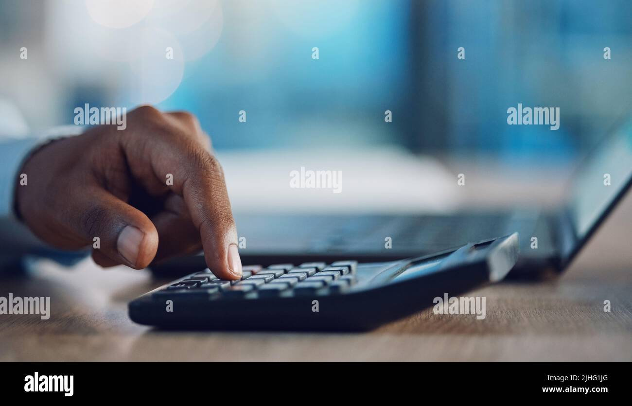 Closeup hands of african man using a calculator while sitting at his ...
