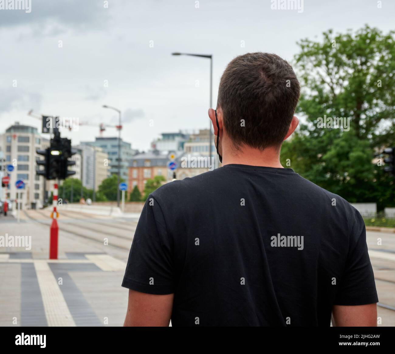 The young man crossing the street via pedestrian crosswalk Stock Photo ...