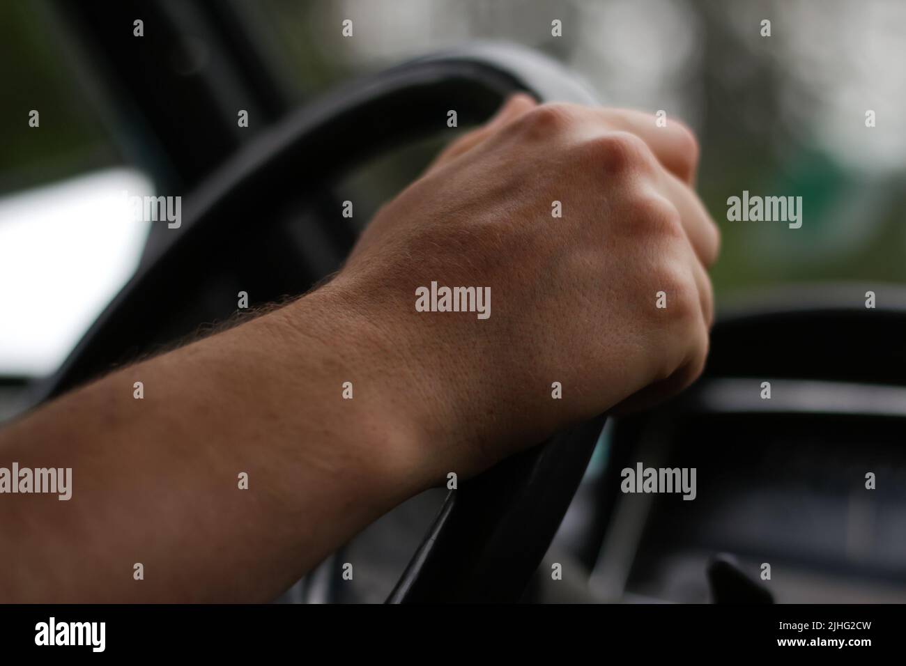 Defocus male hand holding steering wheel. A man's hand handle steering ...