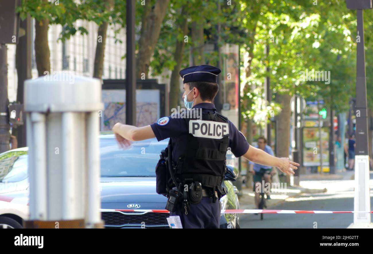 Paris, France. July 14. 2022. Policeman in the street with traffic on ...