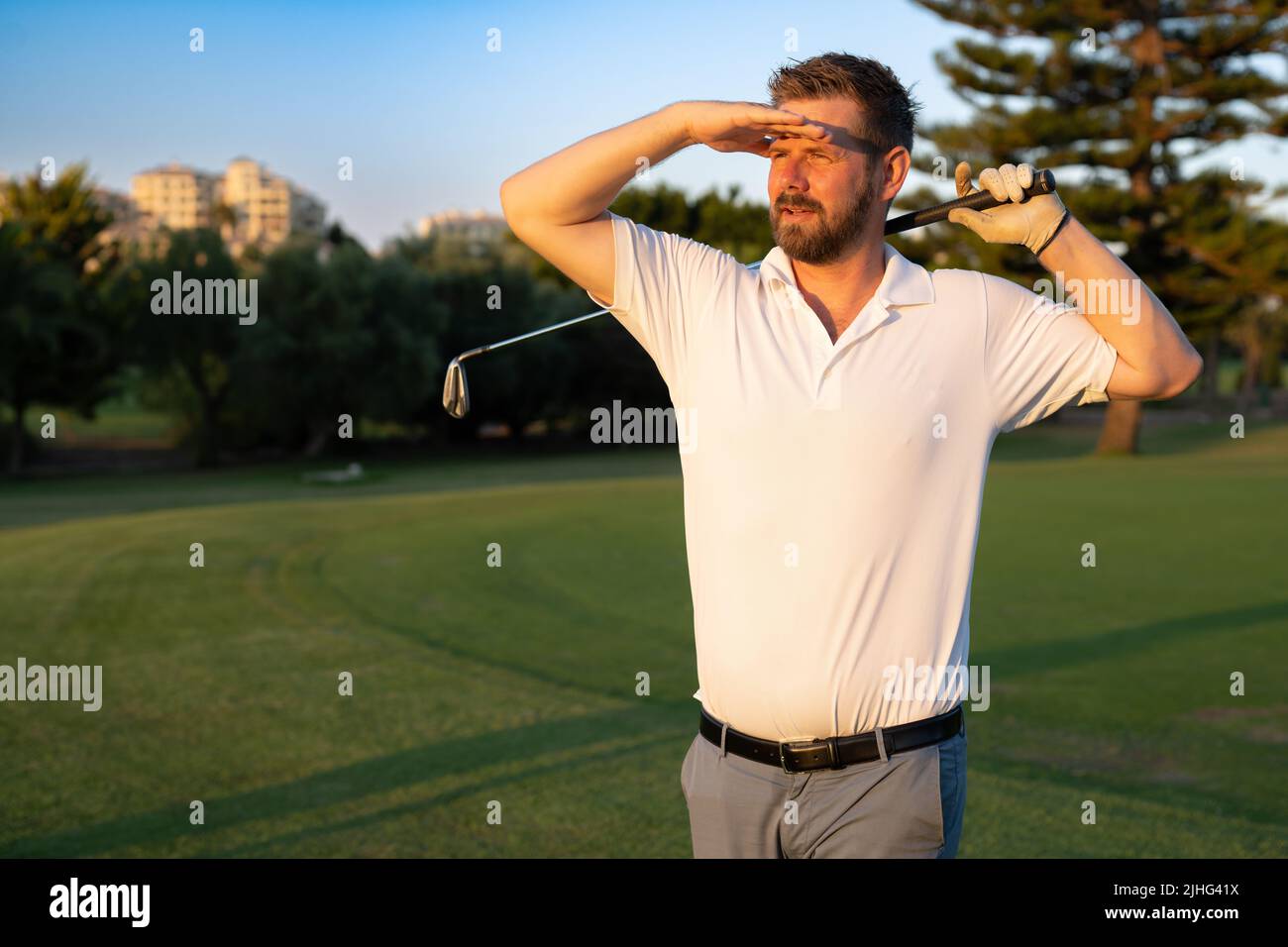 Good strike, golfer swinging his driver and looking away while standing ...