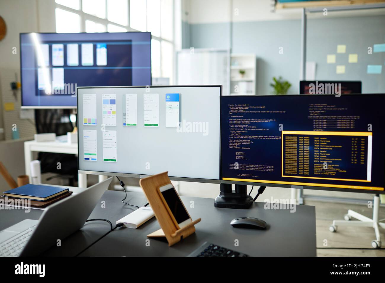 Horizontal image of computer monitors with programs and computer codes on monitors standing on ...