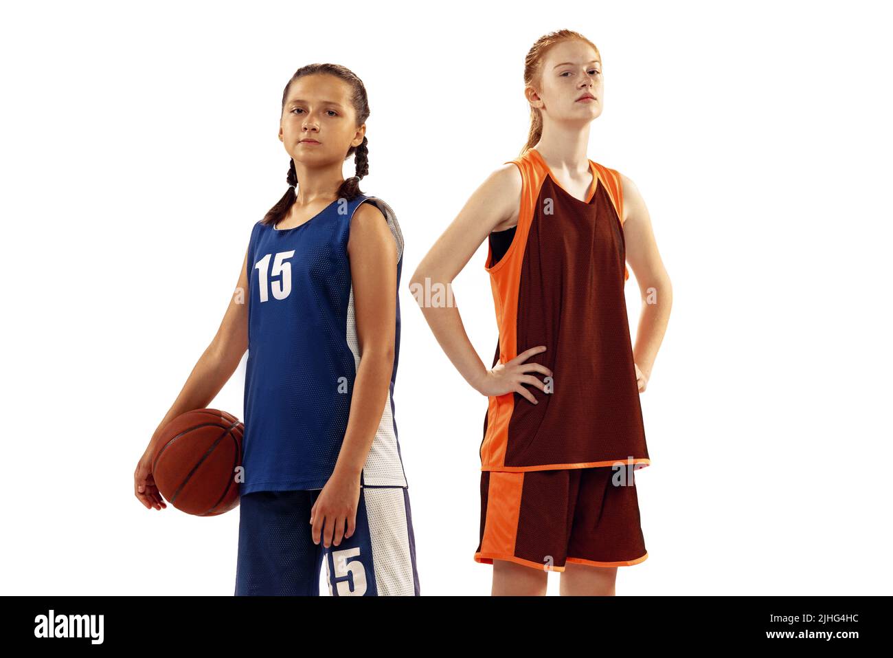 Portrait of two young girls, basketball players posing with basketball ...