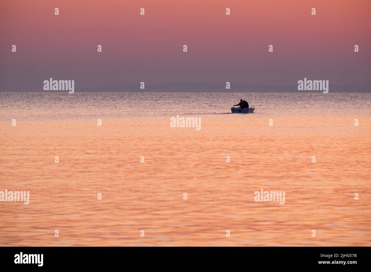 Seascape with a fishing boat heading out to the sea Stock Photo - Alamy