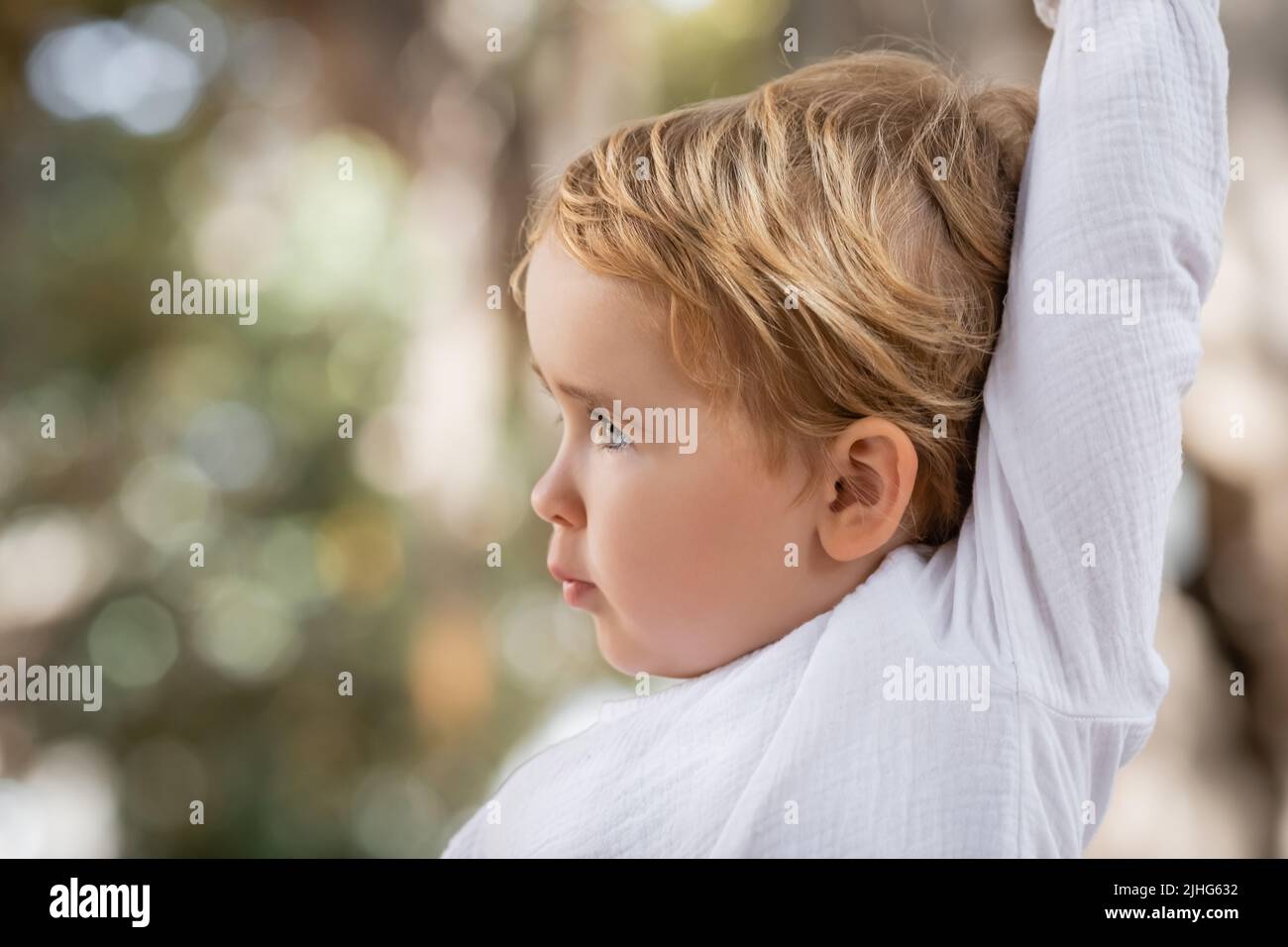 Side view of toddler girl with raising hand outdoors Stock Photo - Alamy