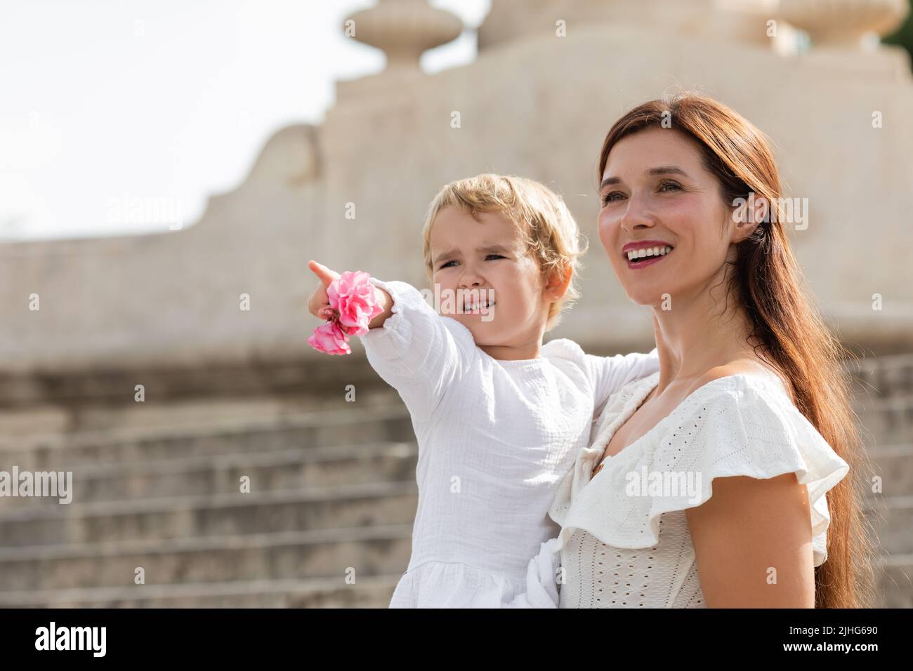Girl holding flowers pointing hi-res stock photography and images - Alamy