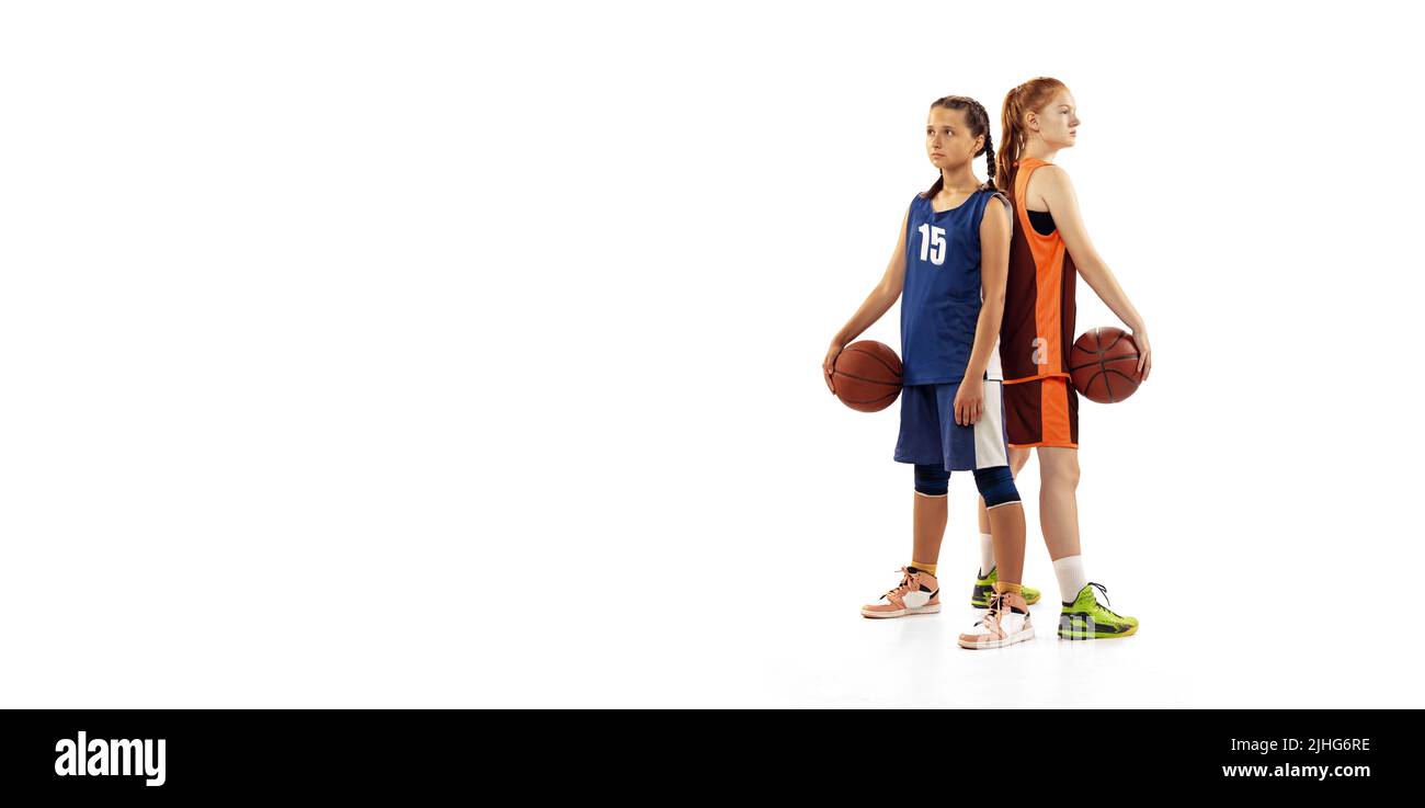 Portrait of two young girls, basketball players posing with basketball ...