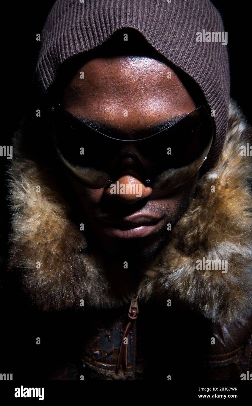 Urban male. A close portrait of a young black male model emerging from ...