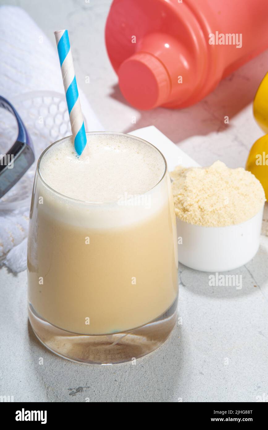 Vanilla white protein shake glass, with straw, with protein powder ...