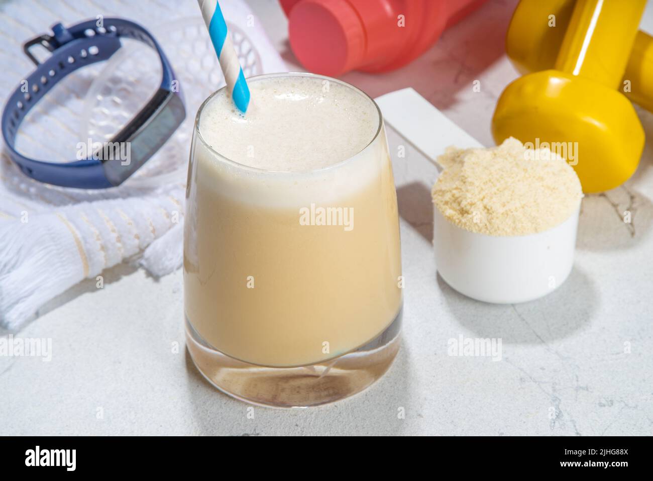 Vanilla white protein shake glass, with straw, with protein powder ...