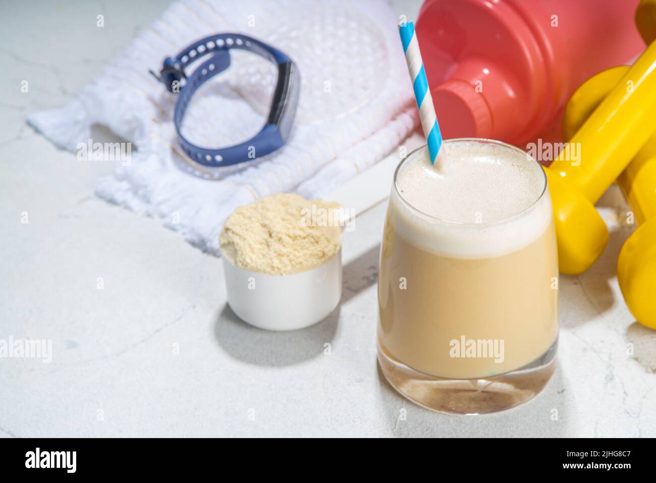 Vanilla white protein shake glass, with straw, with protein powder ...