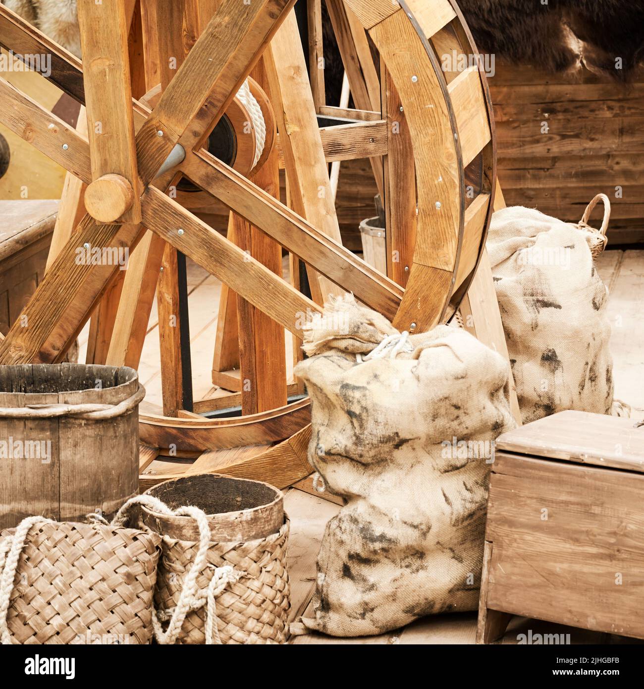 A medieval port with a wooden winch for lifting cargo onto ships ...