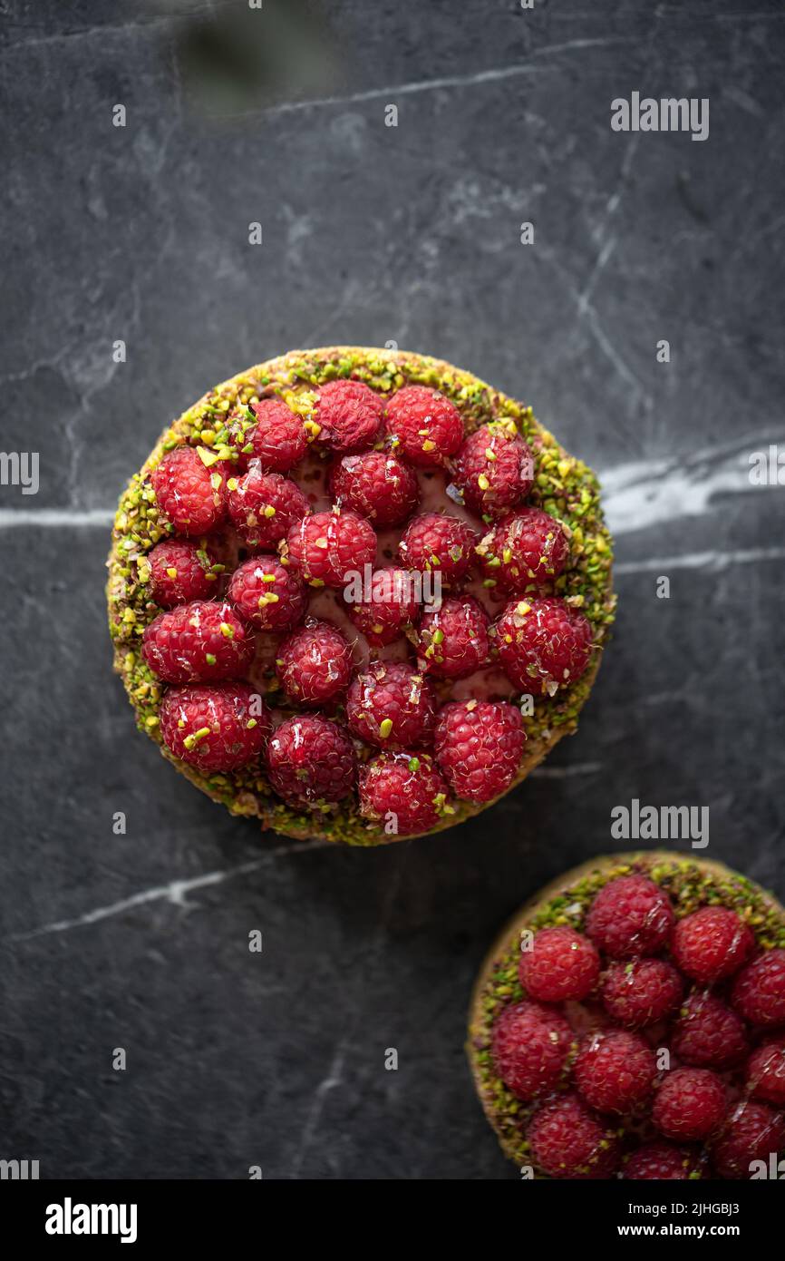Two delicious raspberry tartlets with pistachios Stock Photo - Alamy
