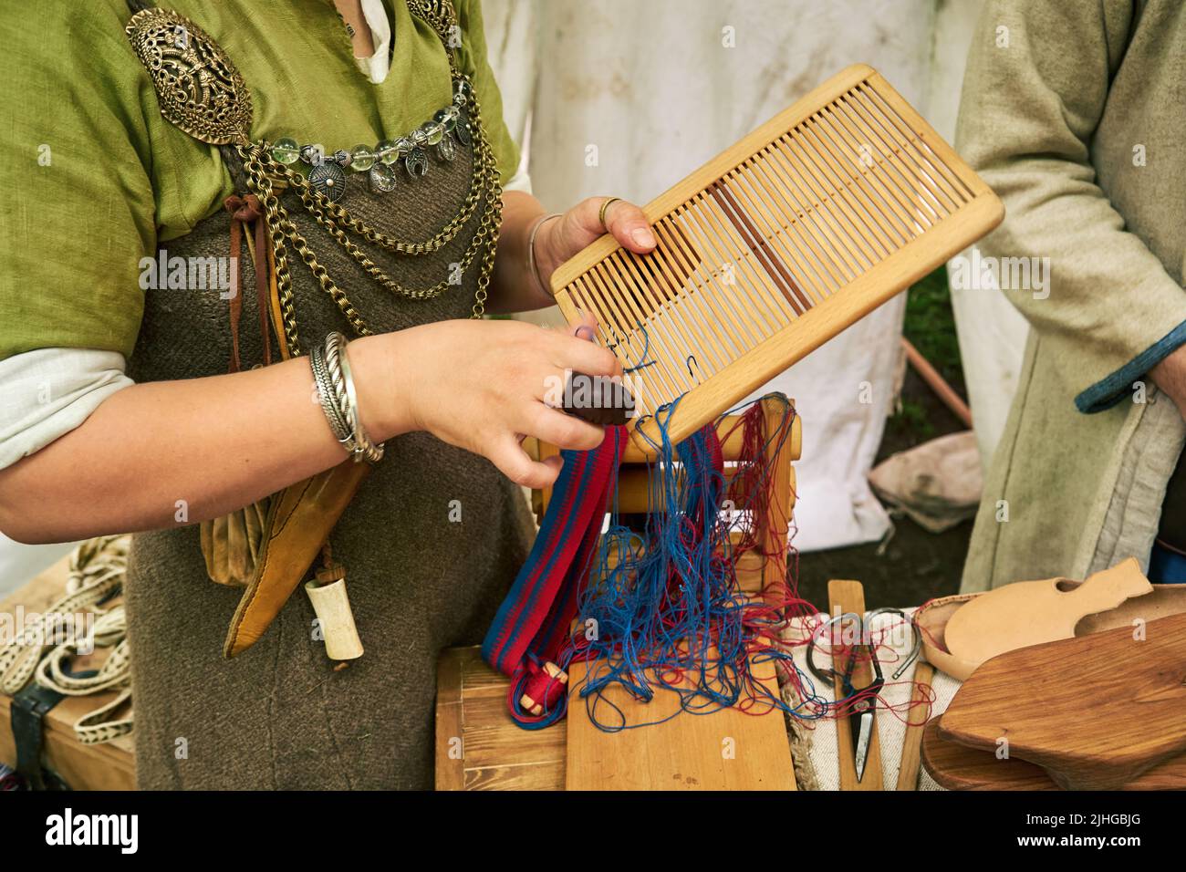 A woman in ancient Byzantine clothing makes yarn and sews from vintage ...